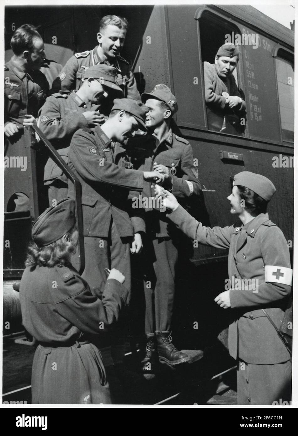 Red cross sisters submit supplies to damaged German soldiers passing ...