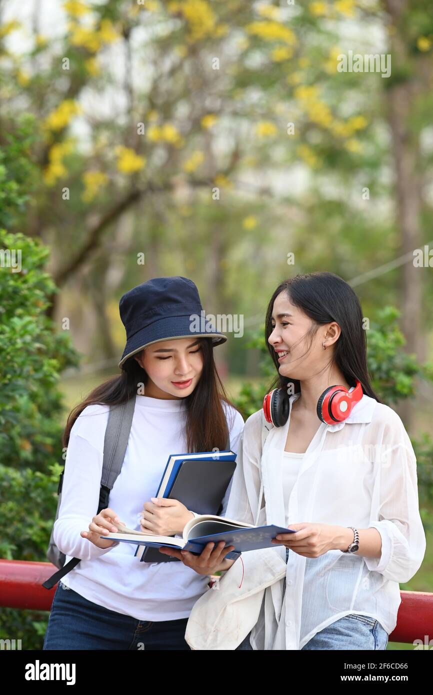 Two asian college student standing in college campus and making ...