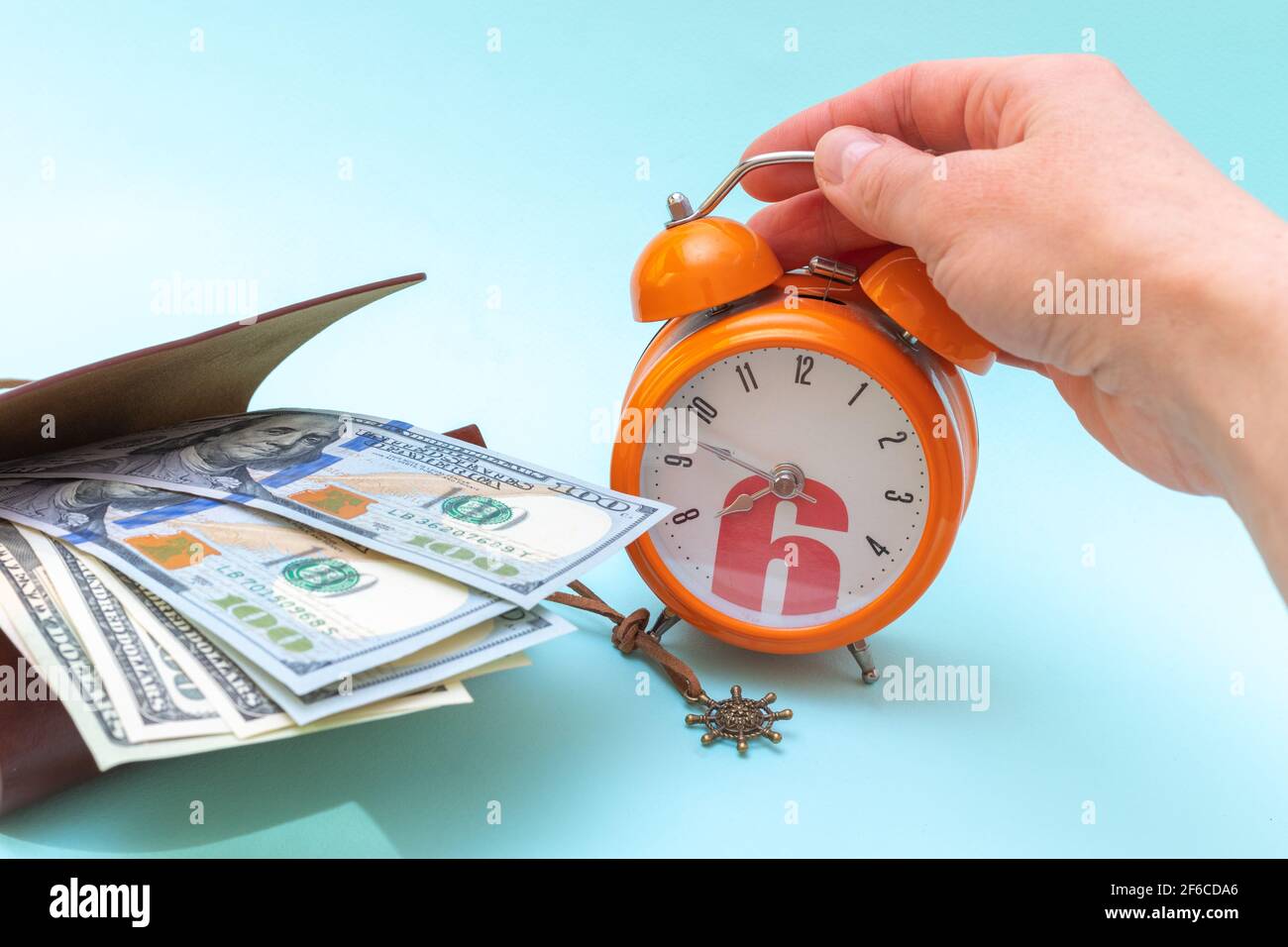 Concept of vacation, travel, adventure. A hand holds an orange alarm ...