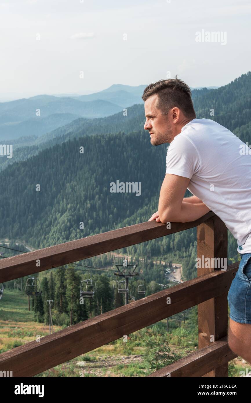 Man standing and looking into the distance in mountains Stock Photo - Alamy