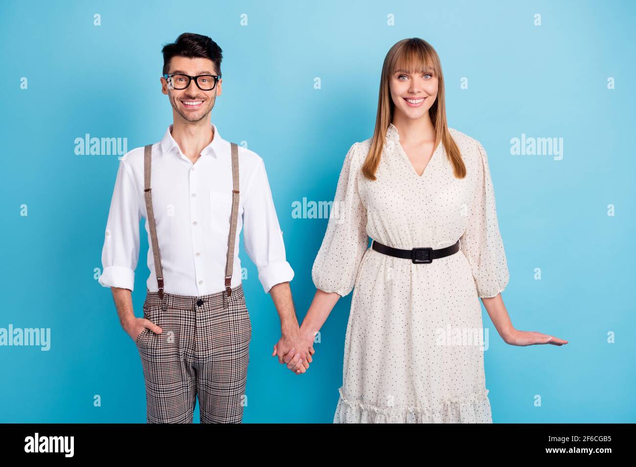 Photo of sweet pretty young couple wear white outfit holding hands arms ...