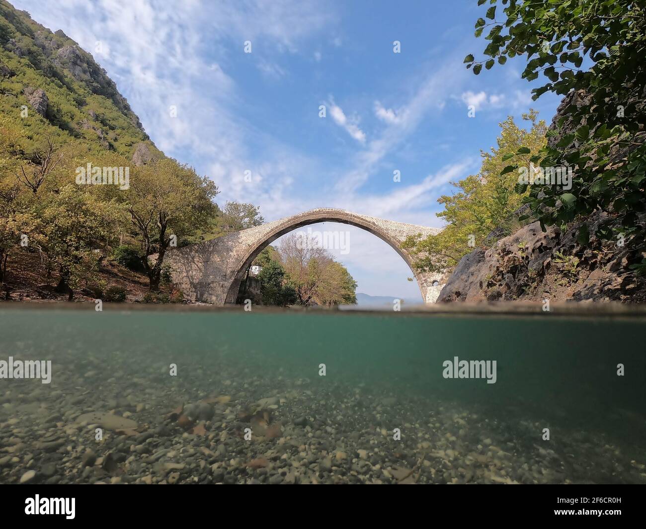 Old stone bridge of Konitsa, Aoos river, half underwater view, Epirus ...