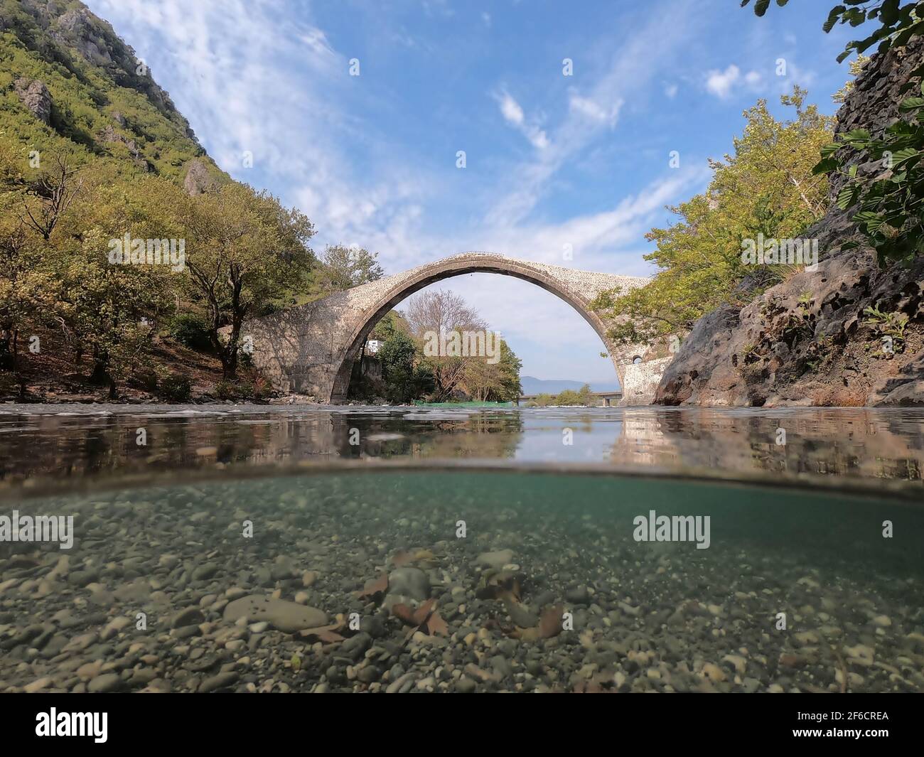 Old stone bridge of Konitsa, Aoos river, half underwater view, Epirus ...