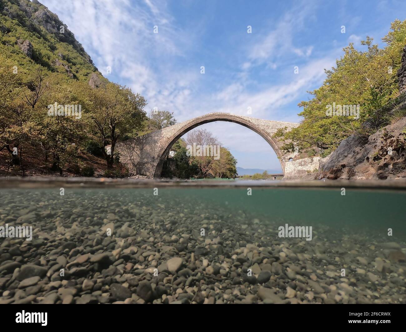 Old stone bridge of Konitsa, Aoos river, half underwater view, Epirus ...