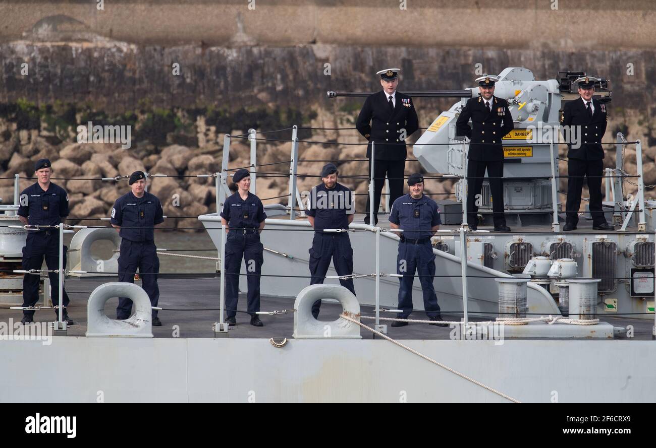 Ships company line the bow of the Royal Navy patrol ship HMS Trent as ...