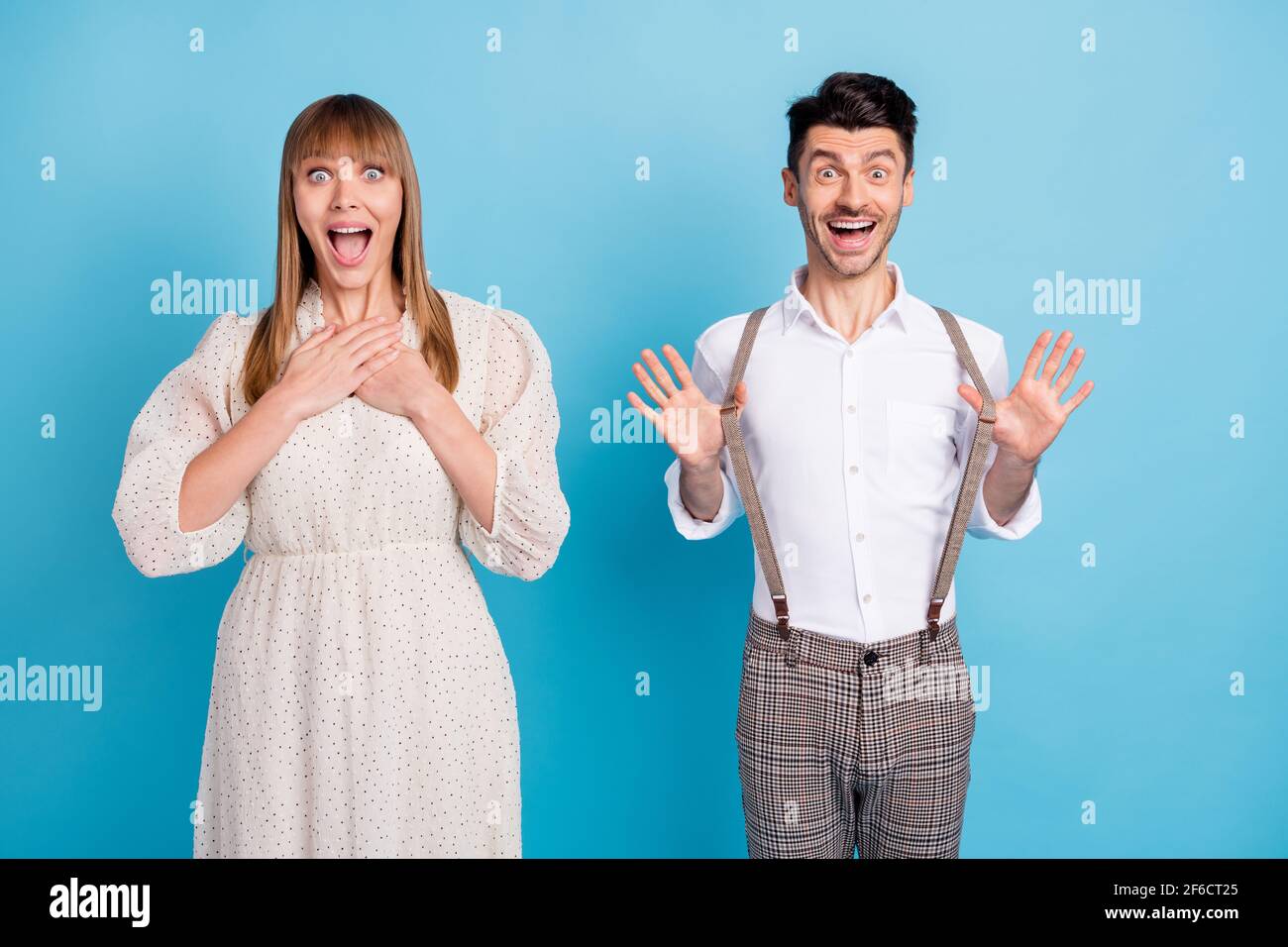 Photo of funky excited young couple wear white outfit open mouth arms ...