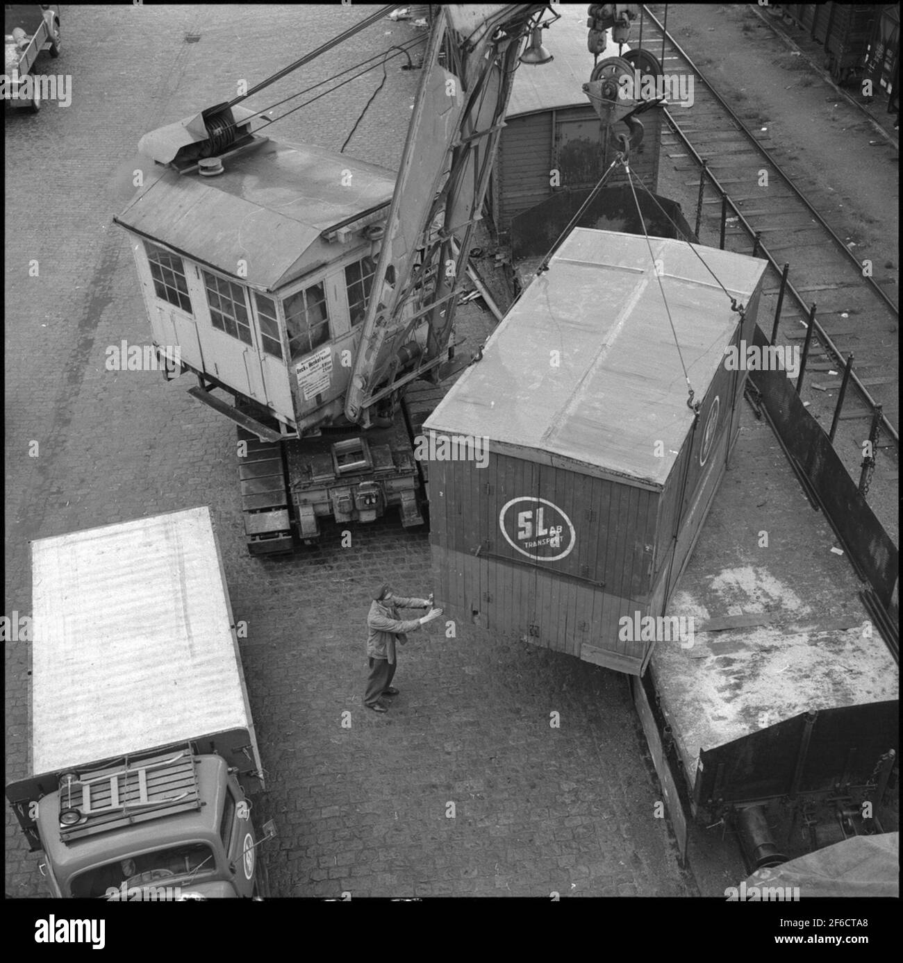 Old lifting crane lifts slab moving box, so-called lift Stock Photo - Alamy