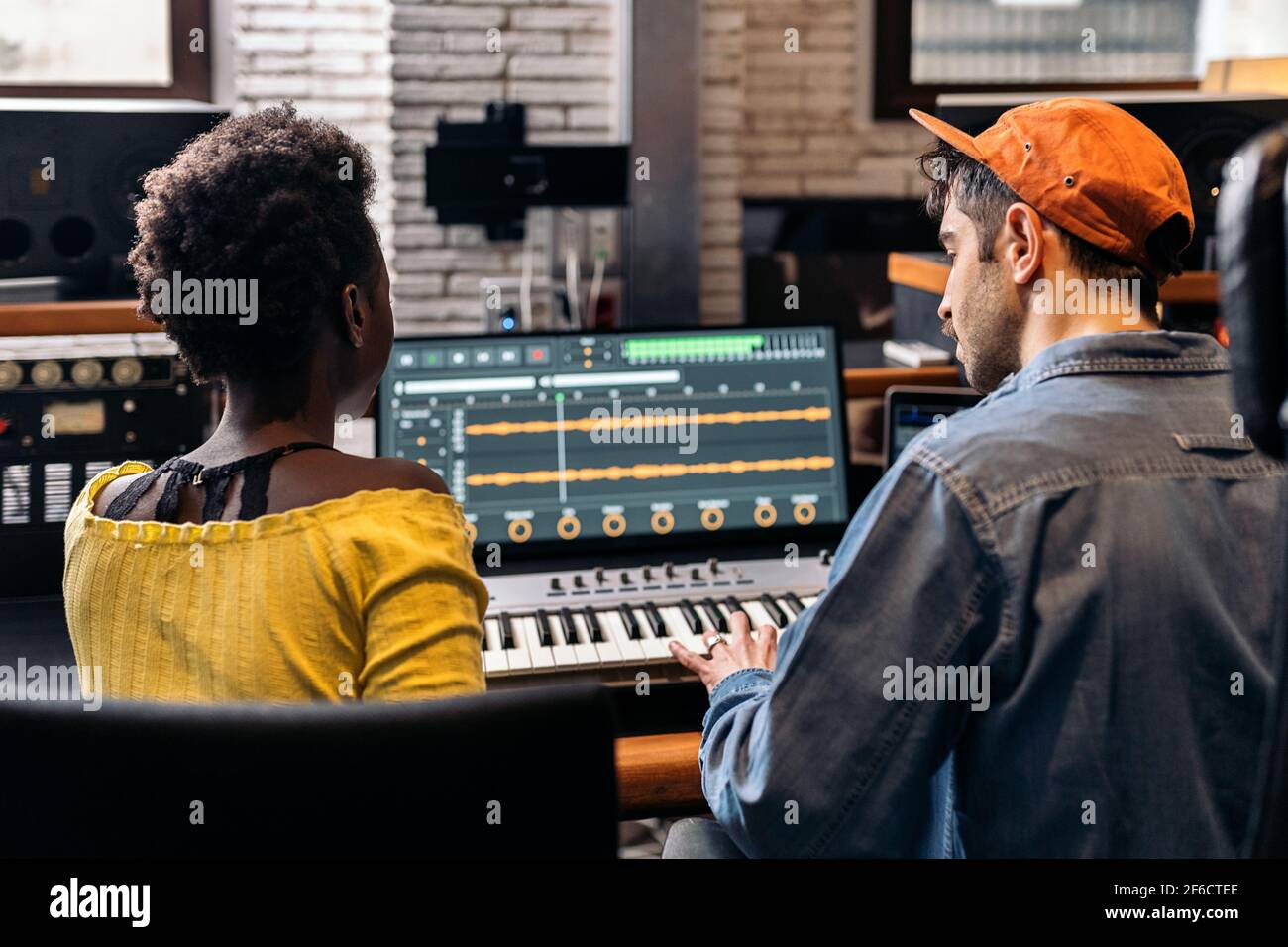 Stock photo of black woman working with male producer in music studio ...