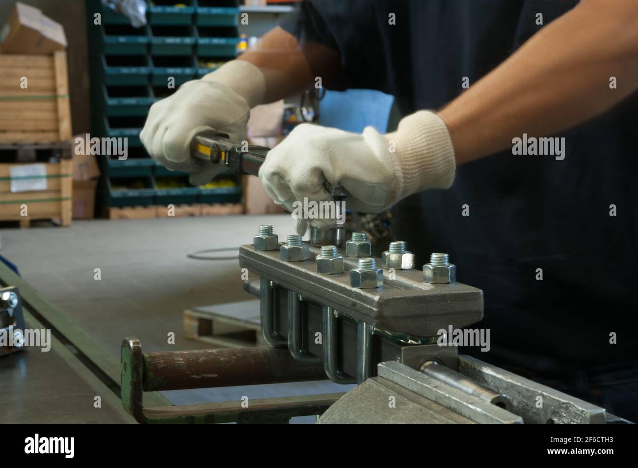 Mechanic in a steel plant working with a wrench on a metallic table ...