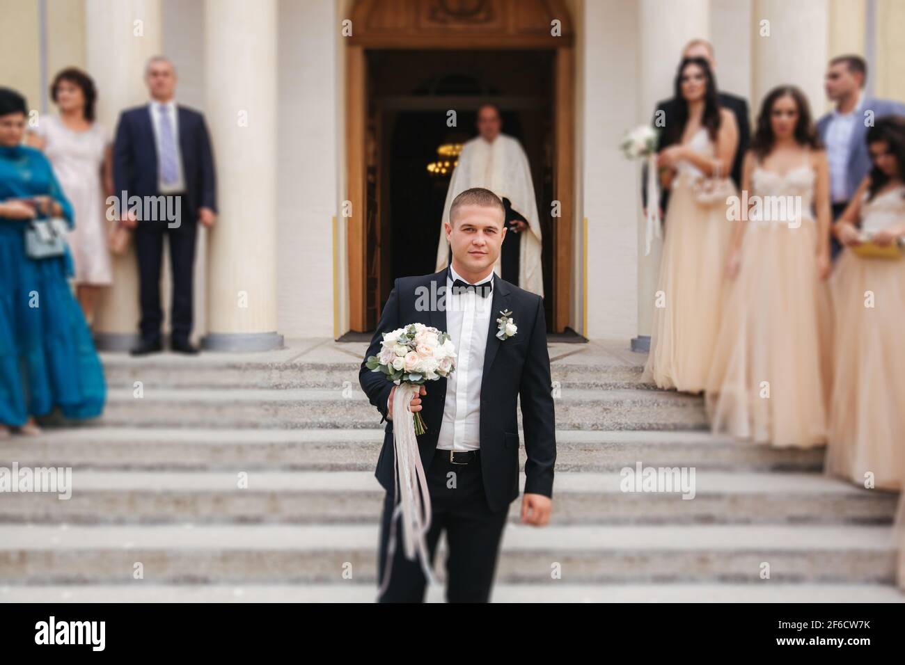 Happy groom wait for the bride by the church Stock Photo - Alamy