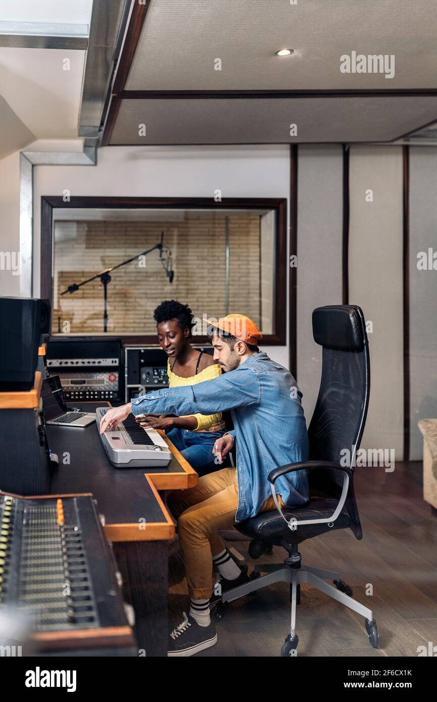 Stock photo of black woman working with male producer in music studio ...