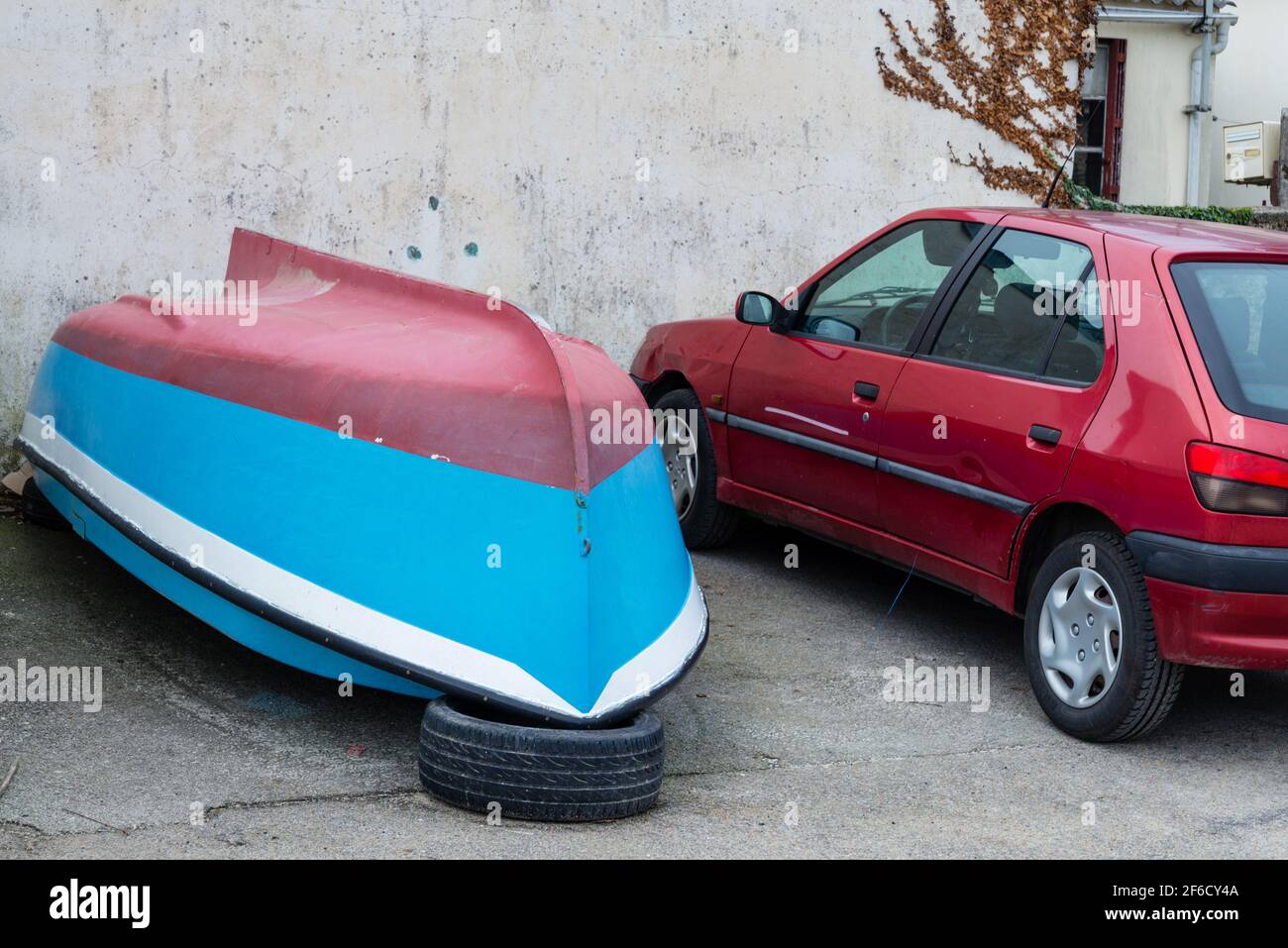 Car and boat on parking place near grey wall of Saint-Pierre Quiberon ...