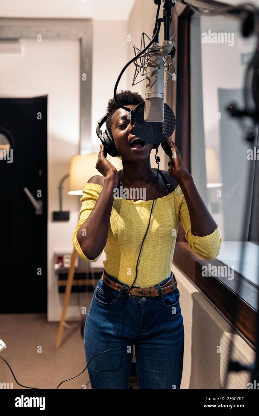 Stock photo of beautiful black woman singing and using microphone in ...