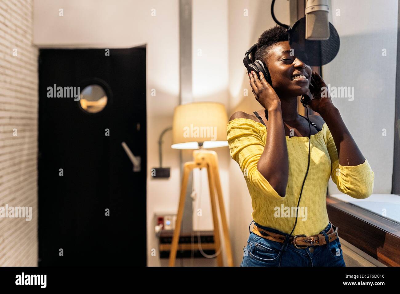 Stock photo of beautiful black woman with headphones using microphone ...
