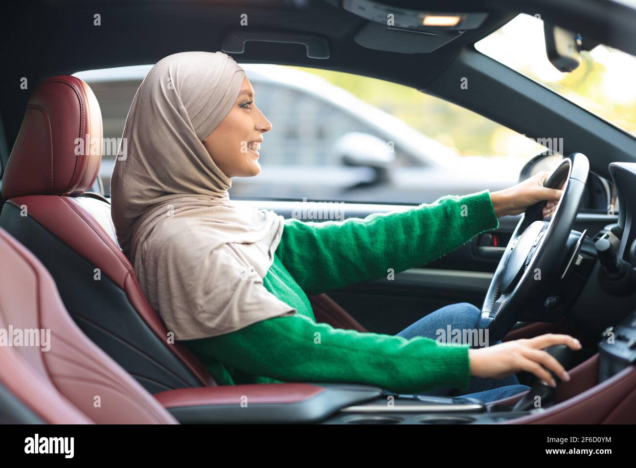 Happy muslim woman test driving new car in urban city Stock Photo - Alamy
