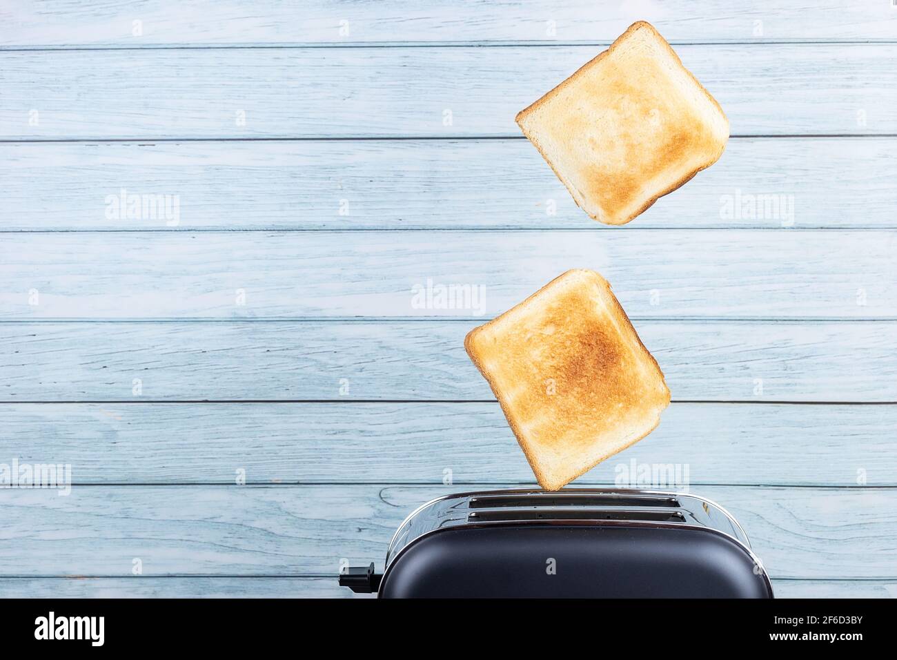 Bread coming out of the toaster with minimalist wooden background Stock ...