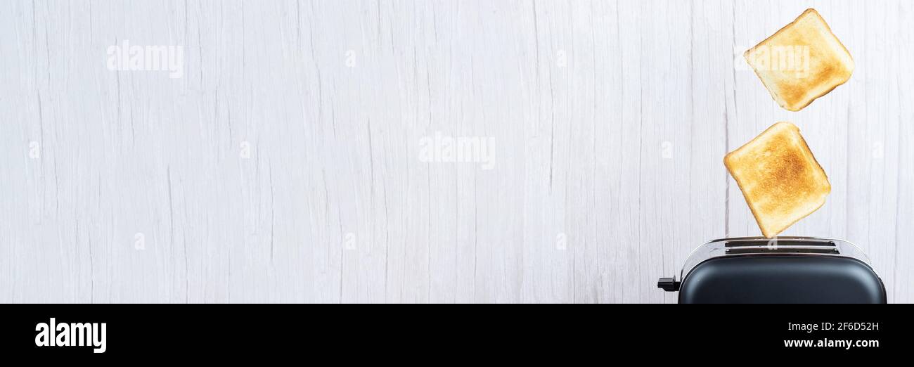 Bread coming out of the toaster with minimalist wooden background Stock ...