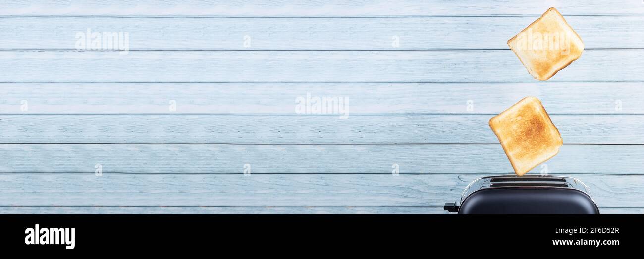 Bread coming out of the toaster with minimalist wooden background Stock ...