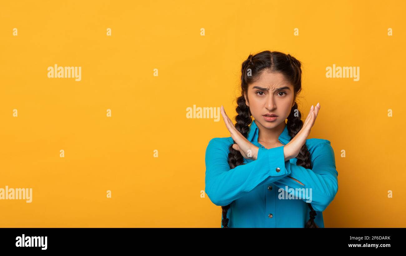 Portrait of serious indian woman crossing arms showing stop gesture ...