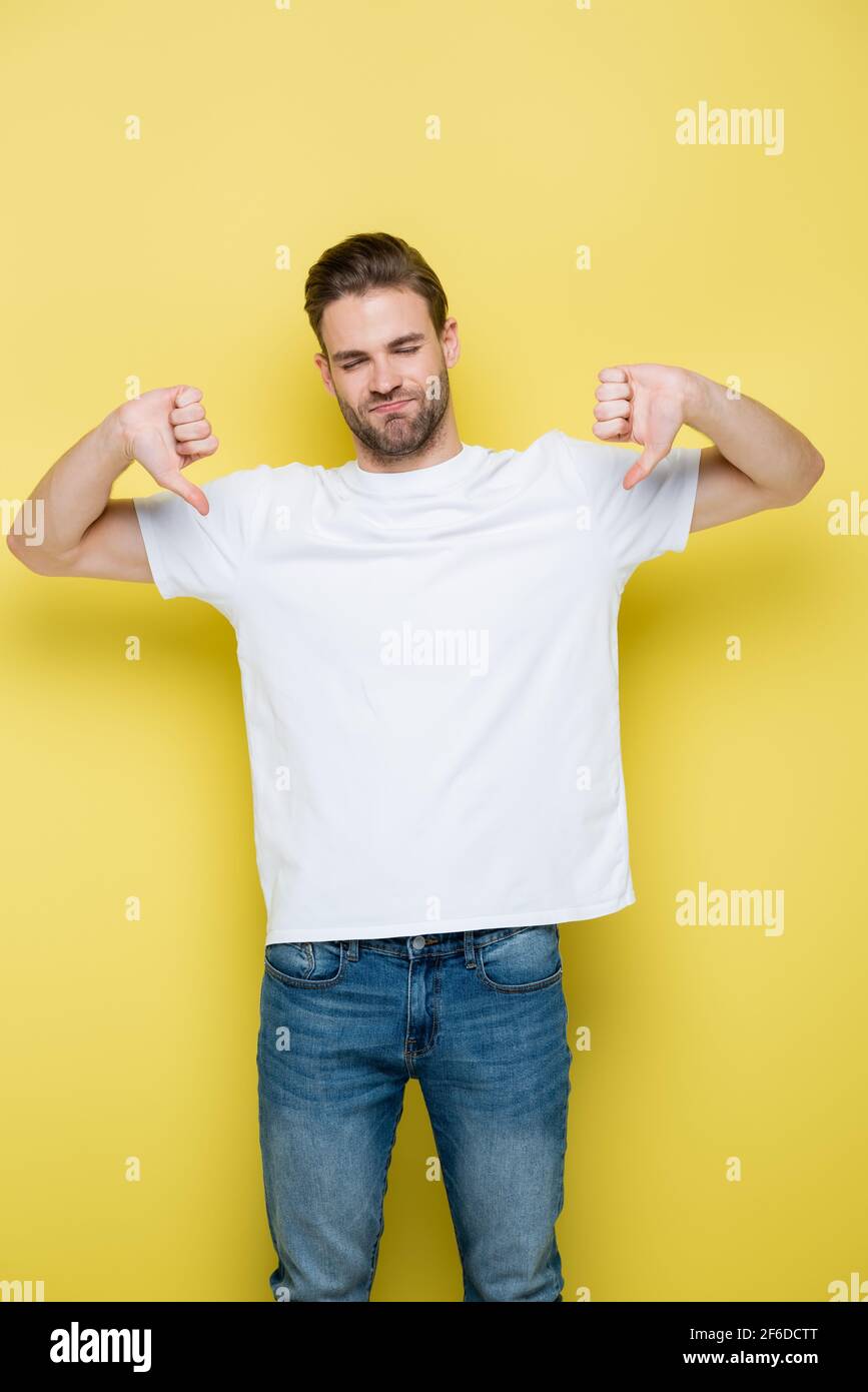 Young man thumbs down yellow hi-res stock photography and images - Alamy
