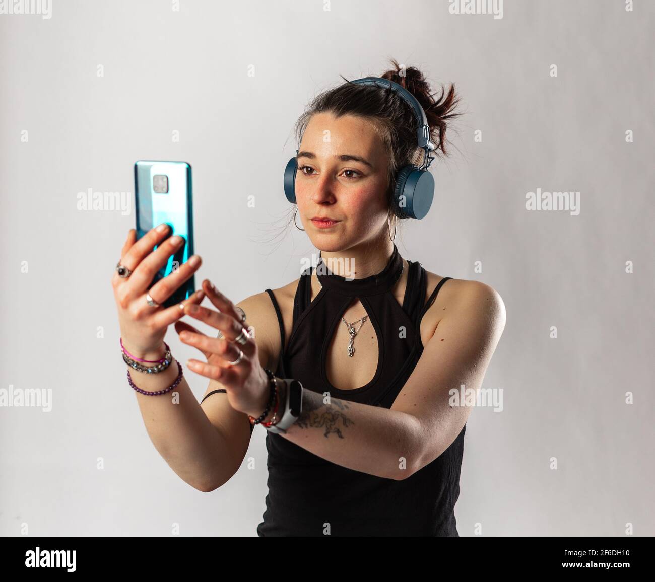 Alternative girl with tattoo using her cell phone and wireless ...