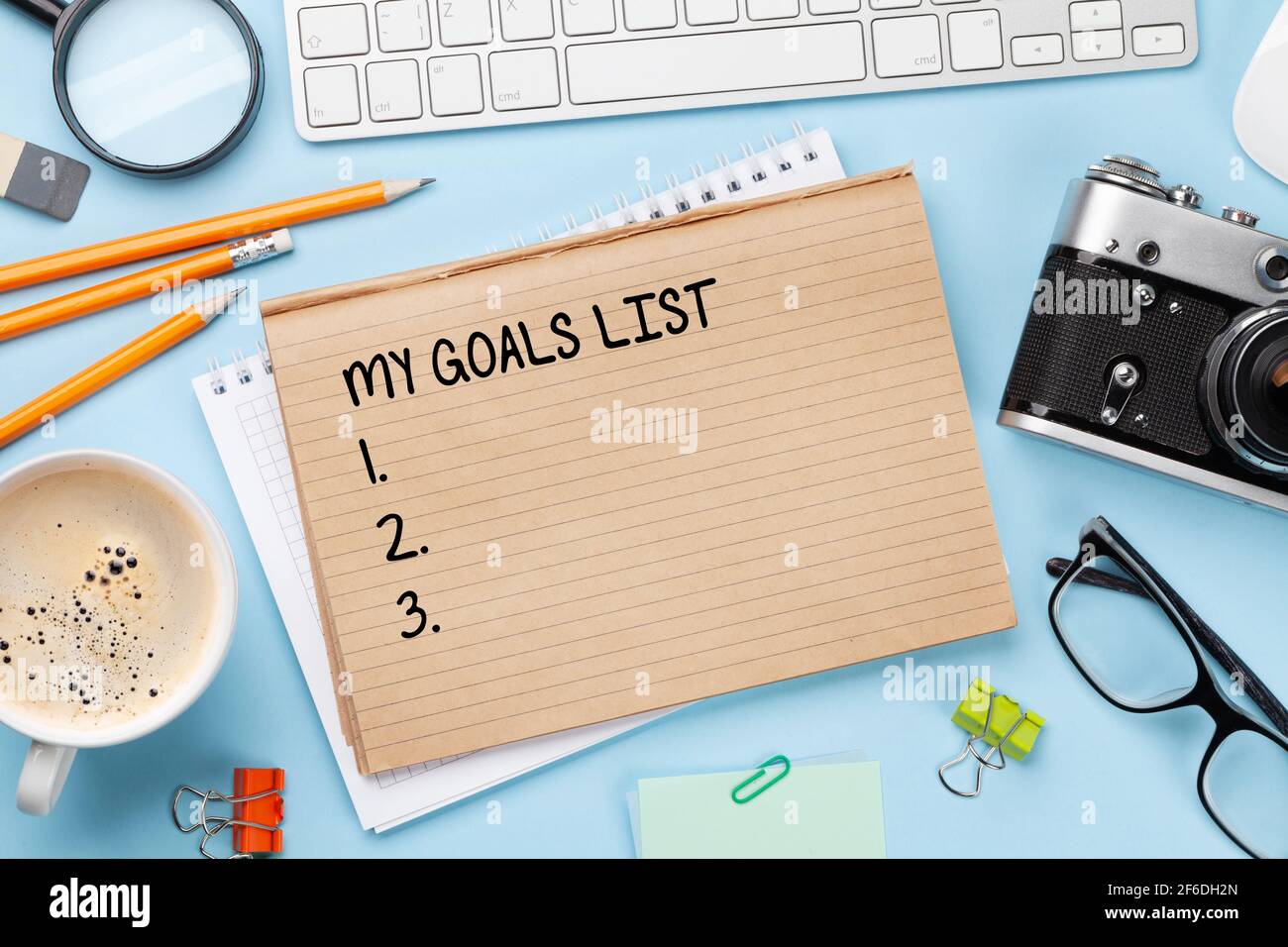 Business desk workplace with goals list notepad and office objects over ...