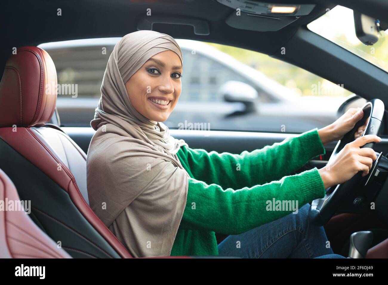 Smiling muslim woman driving her new car in city Stock Photo - Alamy