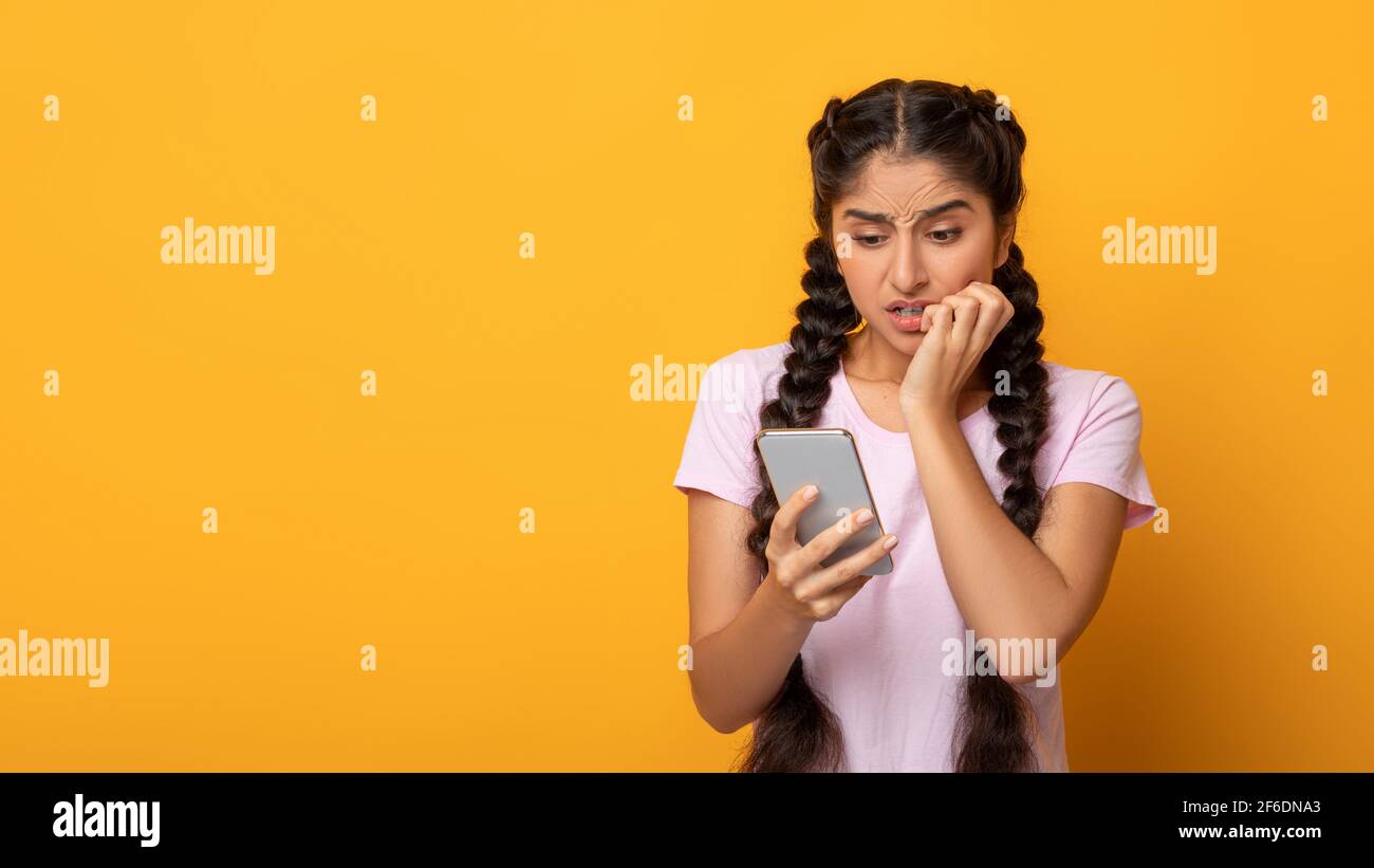 Worried scared indian woman looking at phone seeing bad news Stock ...