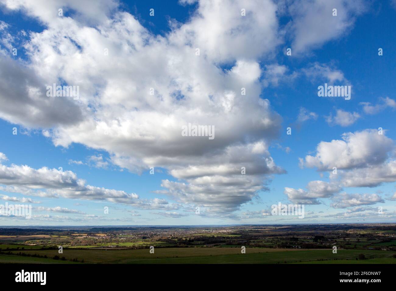 Lines of cumulus clouds in blue sky passing over countryside, Calne ...