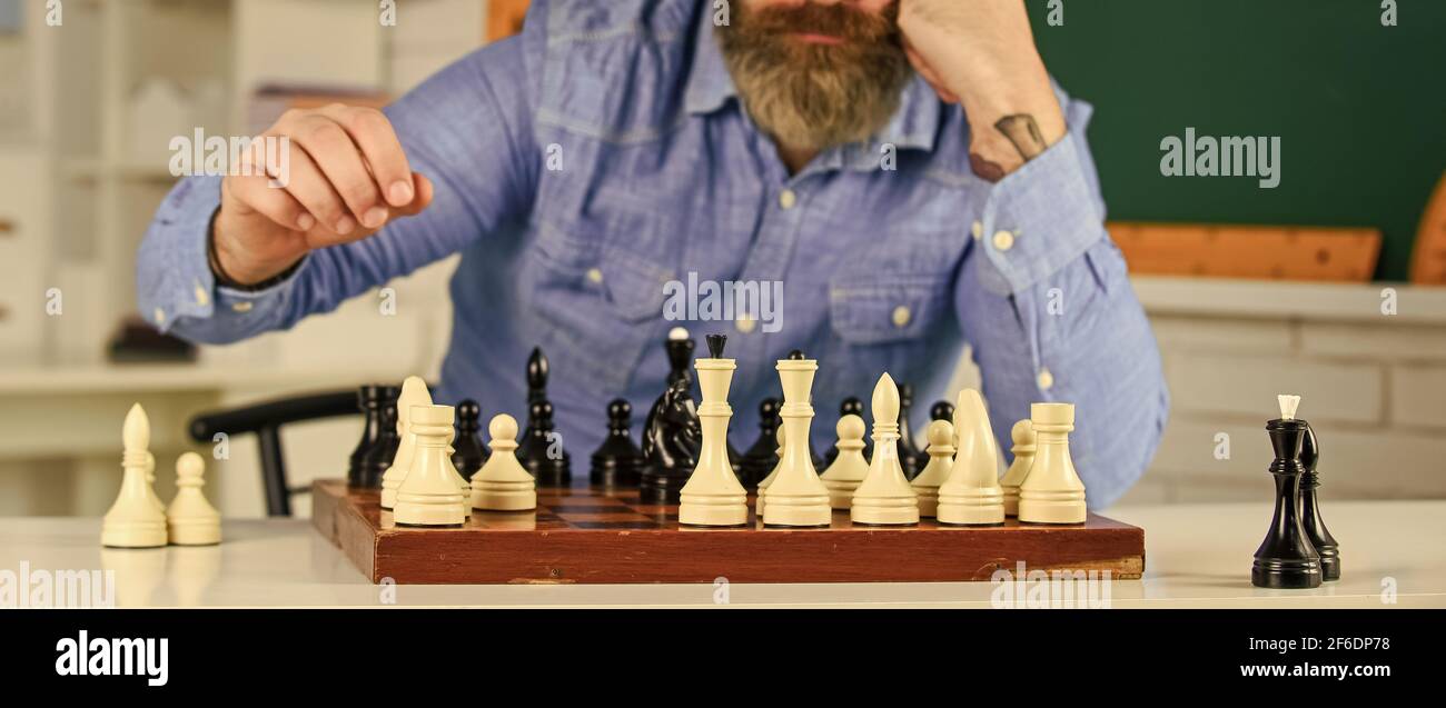 Figures on wooden chess board. Smart hipster man playing chess ...