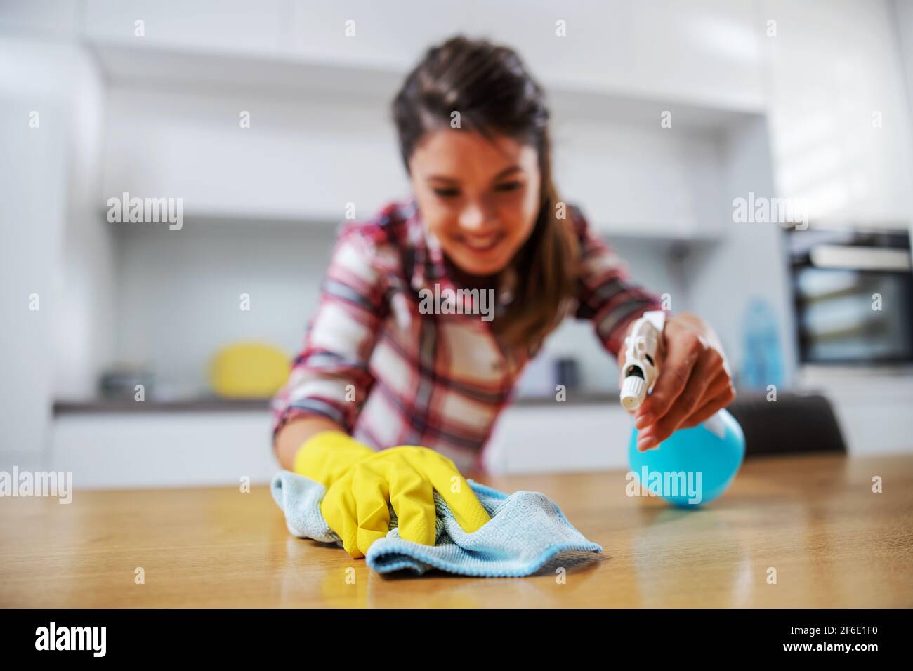Diligent housewife rubbing kitchen table with detergent Stock Photo - Alamy