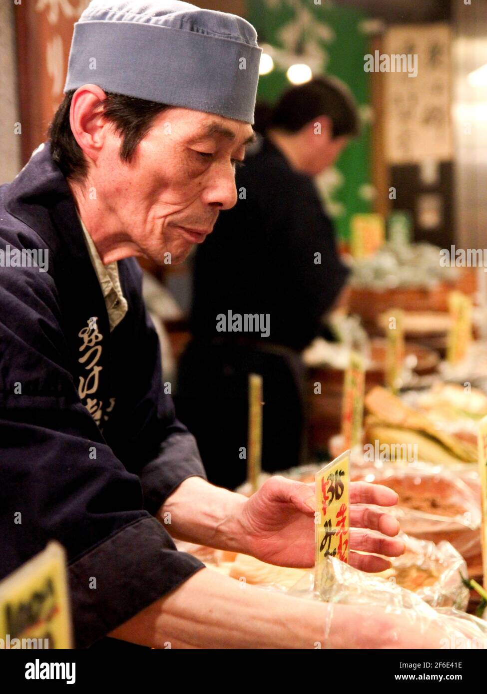 A typical merchant at a dried fish stall at one of the old, traditional ...