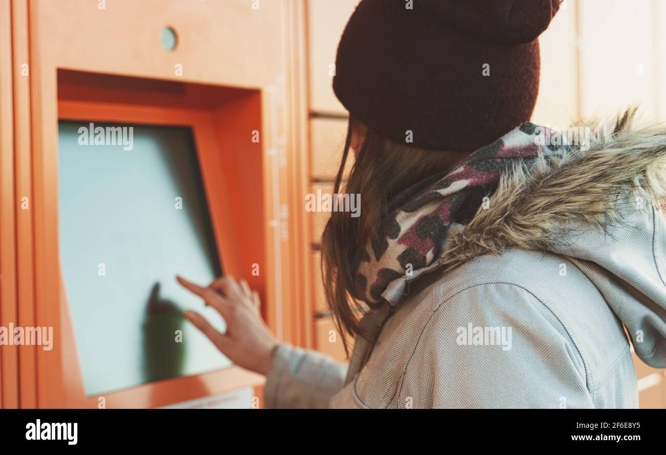 Woman picks up mail from automated self-service post terminal machine ...