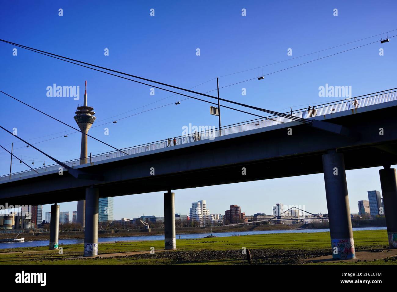 The cable-stayed Rheinkniebrücke in Düsseldorf with people walking. The ...