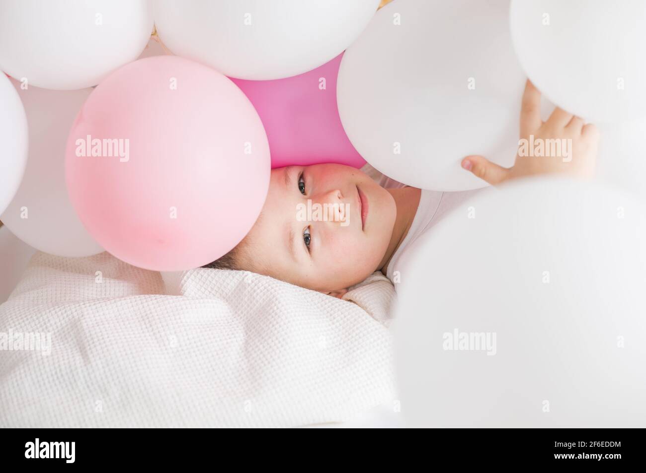 Faceless child in helium balloons celebrates birthday over white ...