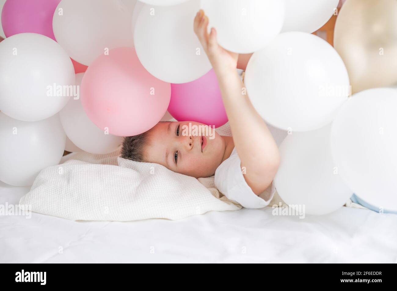 Faceless child in helium balloons celebrates birthday over white ...