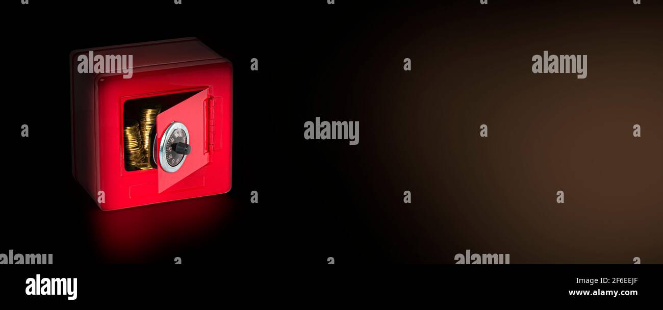 Red Safe with gold coins on a black background with copy space ...