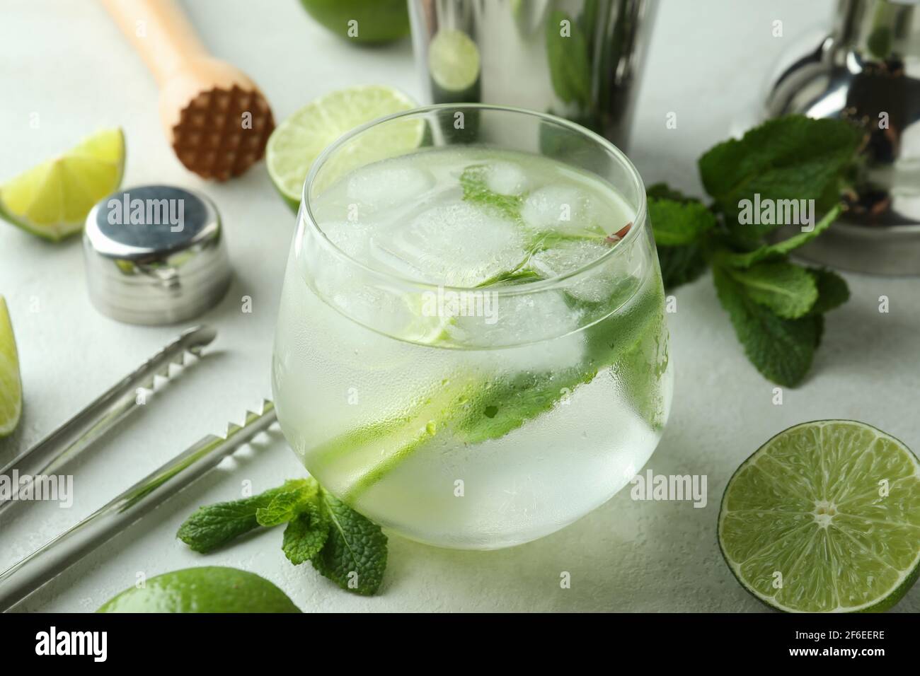 Glass of mojito cocktail and ingredients on white textured table Stock ...