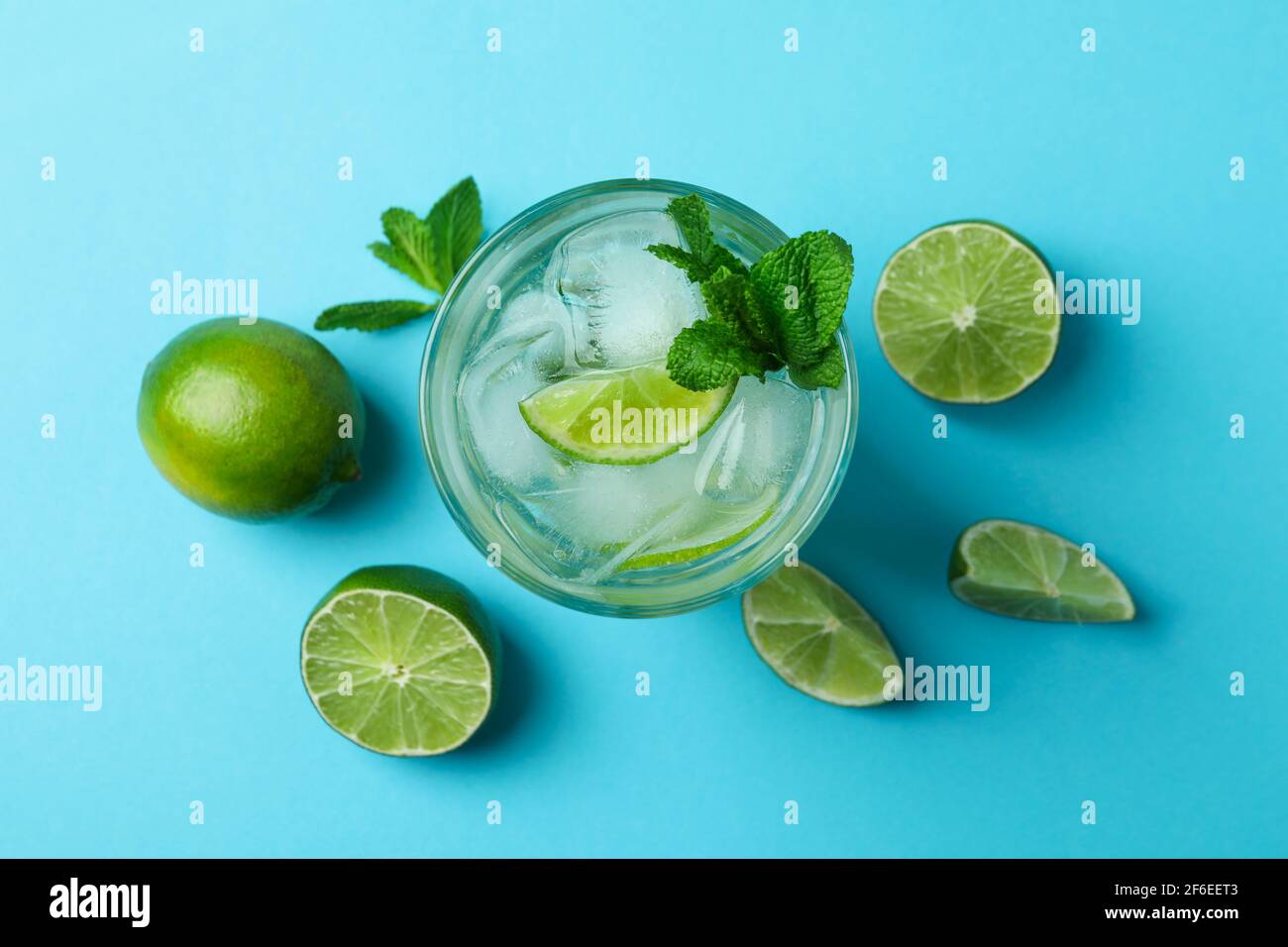 Glass of mojito cocktail and ingredients on blue background Stock Photo ...