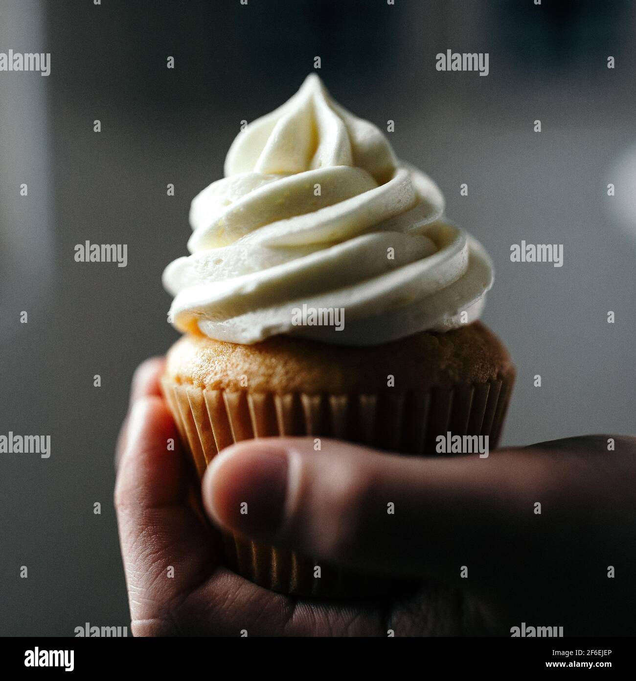 hand holding vanilla cupcake Stock Photo - Alamy