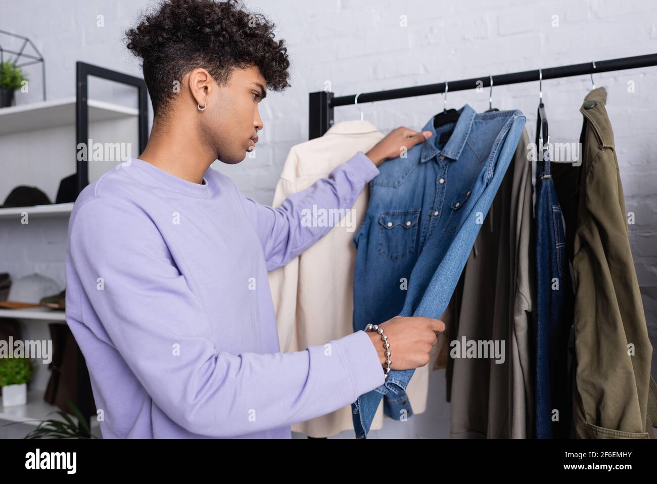 African american owner of showroom looking at denim shirt Stock Photo ...