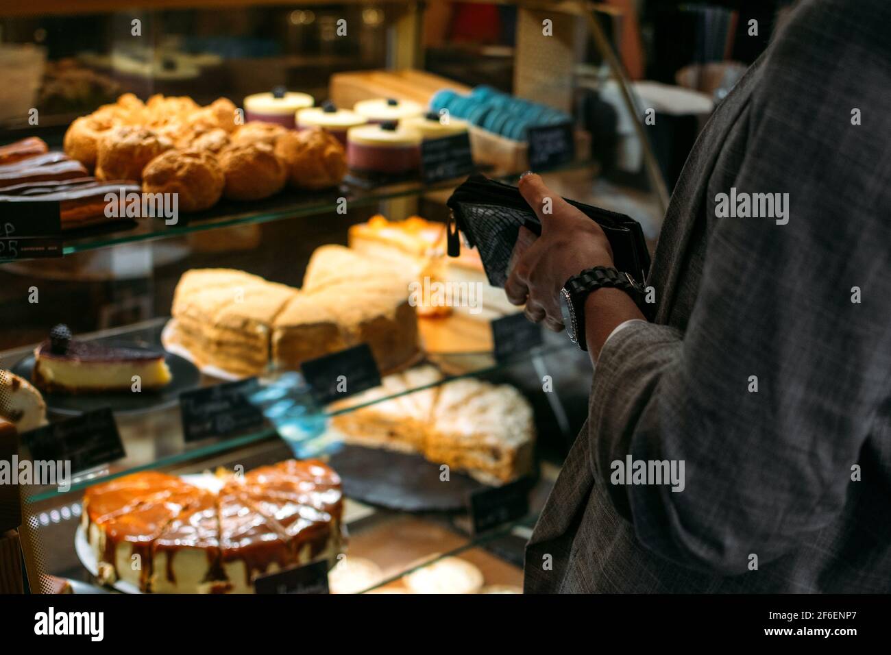 Confectionery customer, client in sweet-shop, pastry-shop. Back view of ...