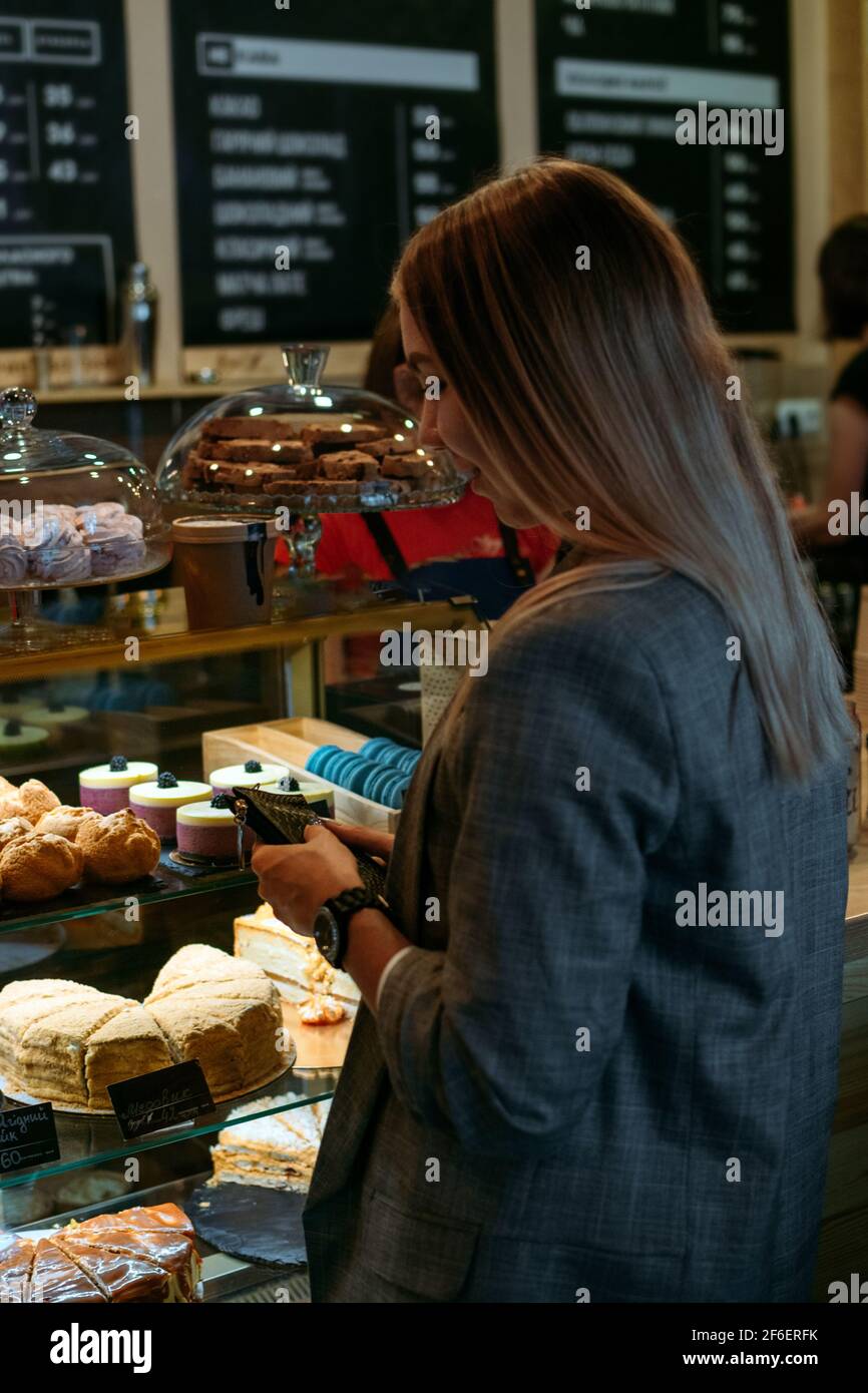 Confectionery customer, client in sweet-shop, pastry-shop. Back view of ...