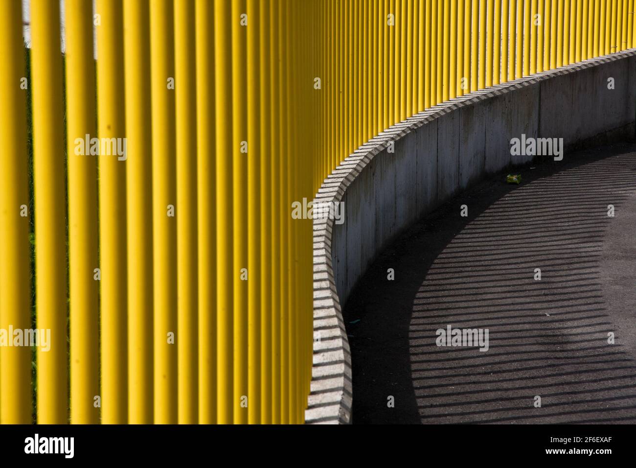 Curved yellow wall of posts and concrete Stock Photo - Alamy