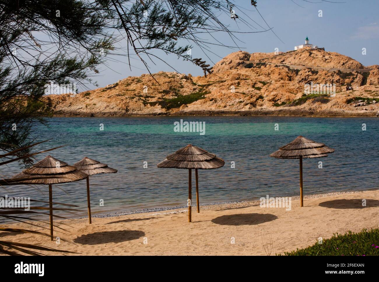 Beach umbrellas on a deserted beach with mountain and lighthouse Stock ...