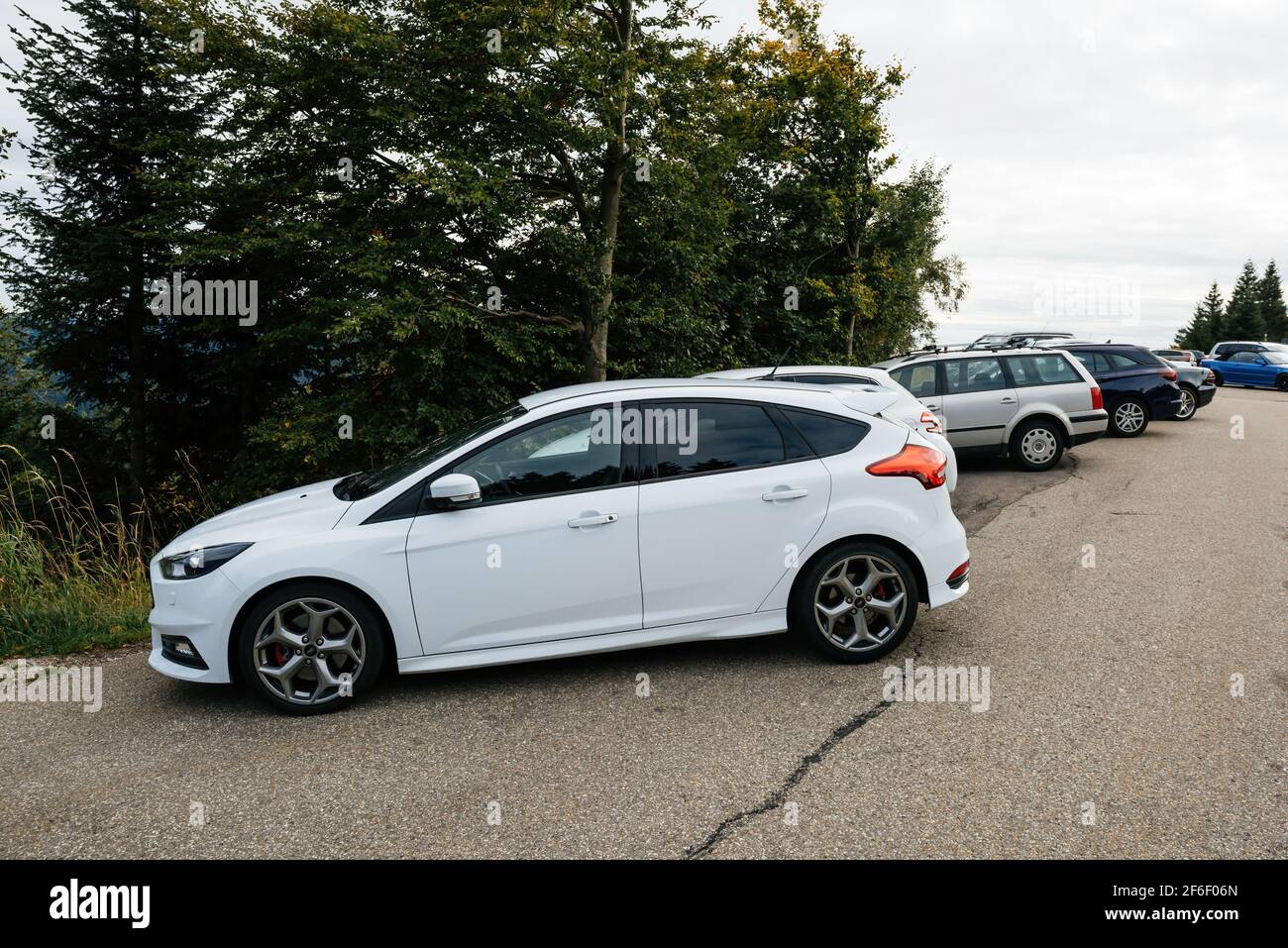 Side view at the white sport Ford hatchback car parked on empty parked ...