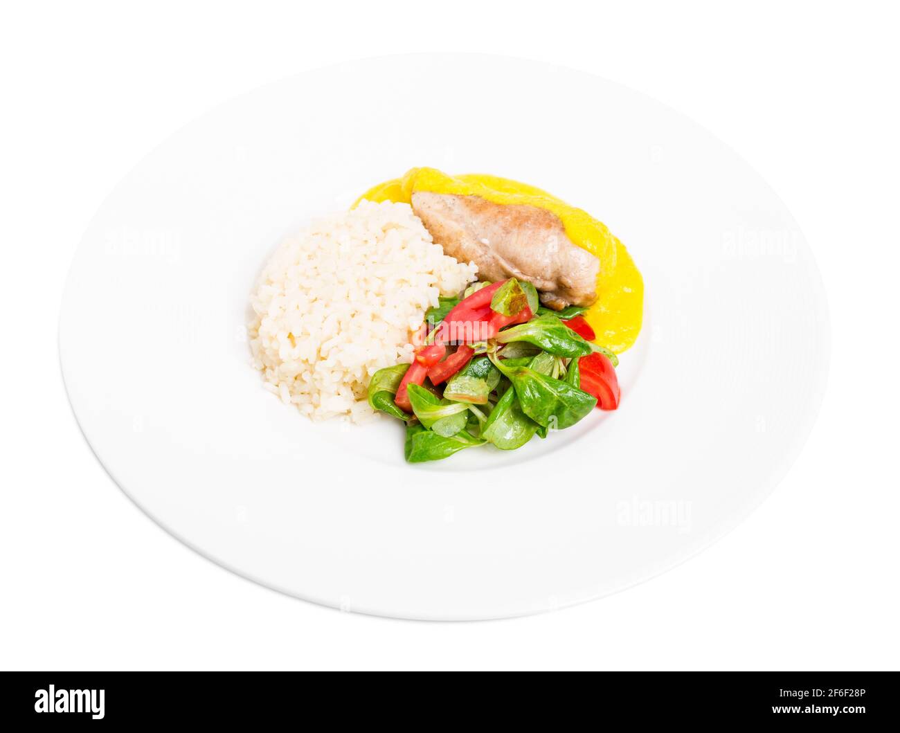 Roasted chicken fillet with rice and fresh vegetables as a garnish ...