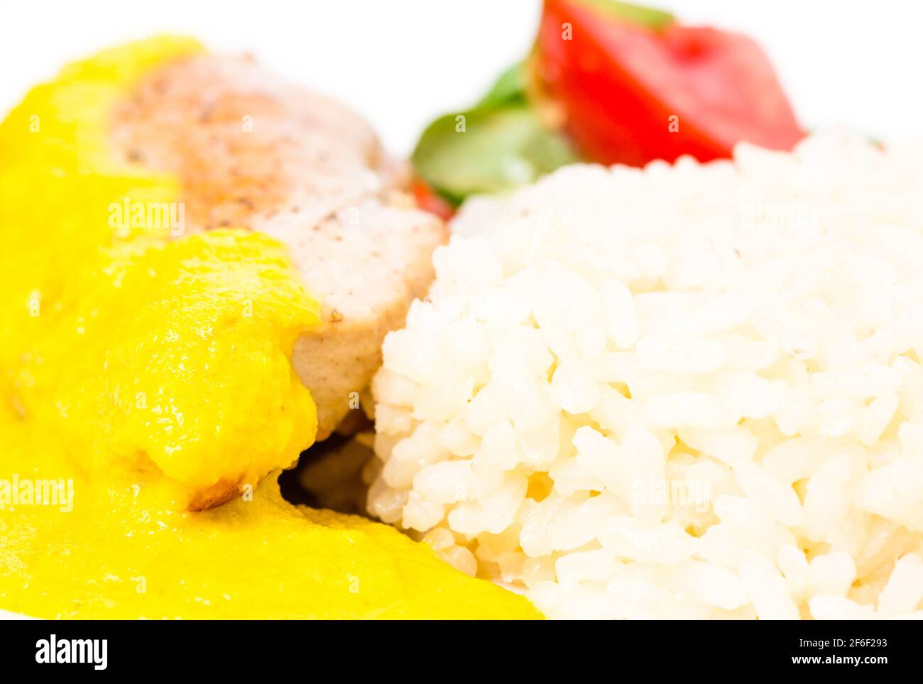 Roasted chicken fillet with rice and fresh vegetables as a garnish ...