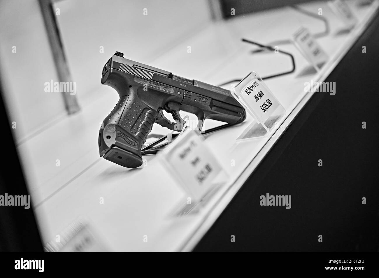 Handguns with labels and price tags on sale on shelves at gun store ...