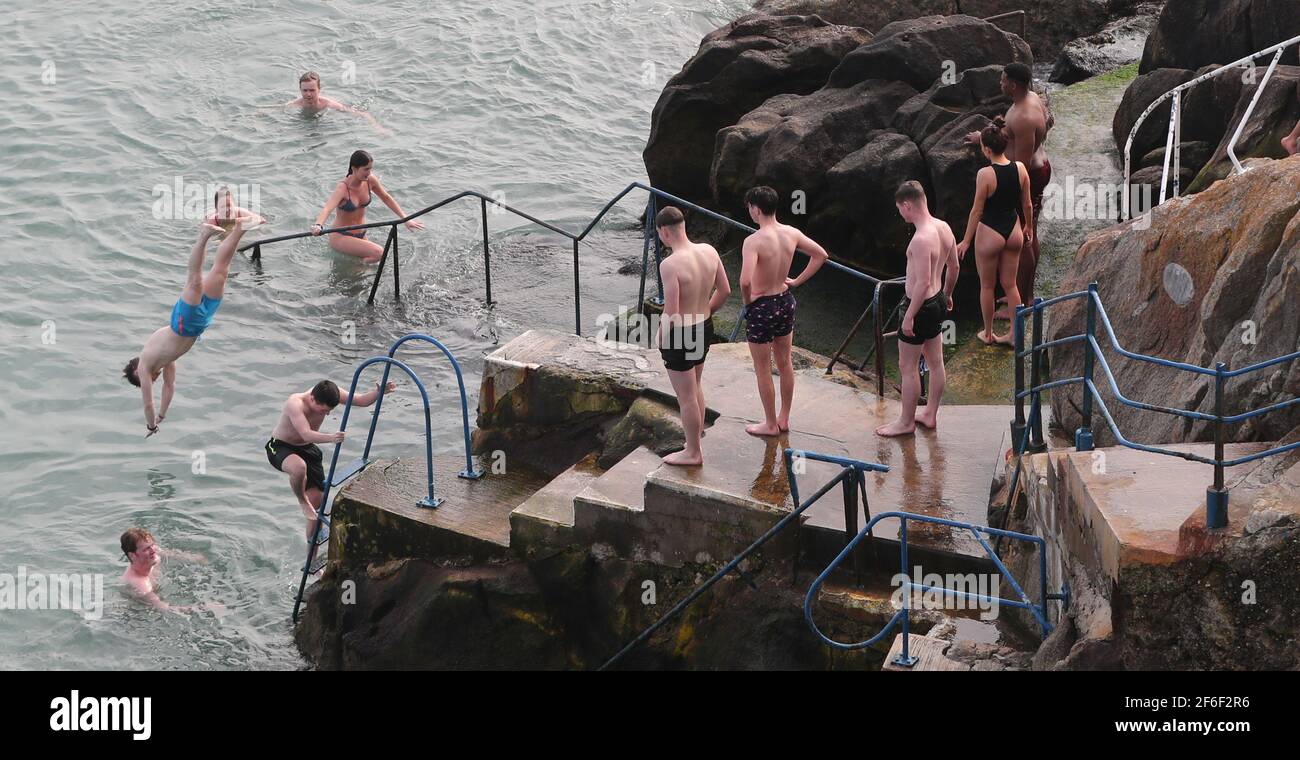 People enjoy the spring sunshine at the Vico bathing place, Hawk Cliff ...